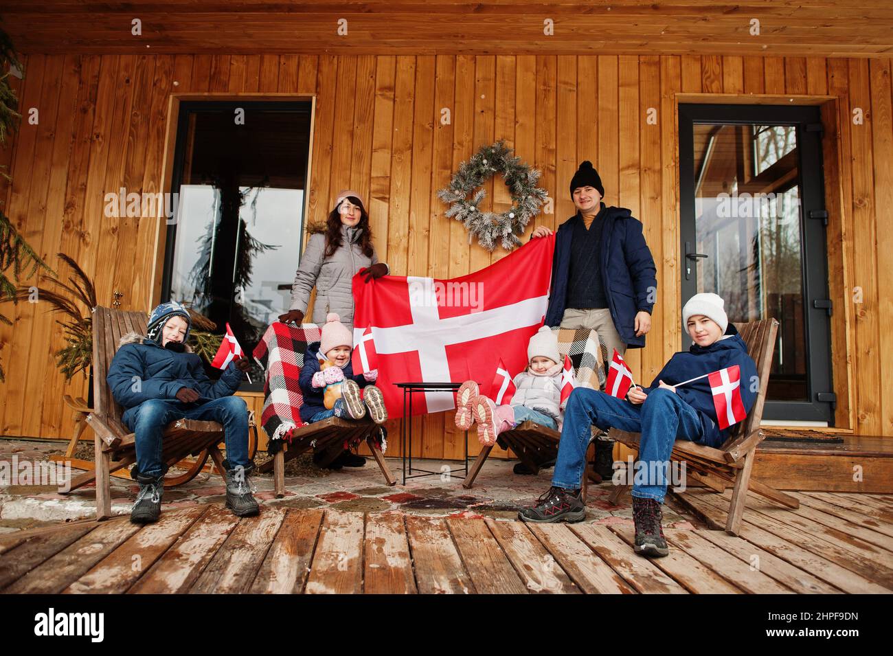 Family with Denmark flags near they wooden house. Travel to ...