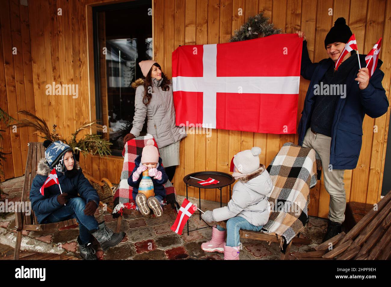 Family with Denmark flags near they wooden house. Travel to ...