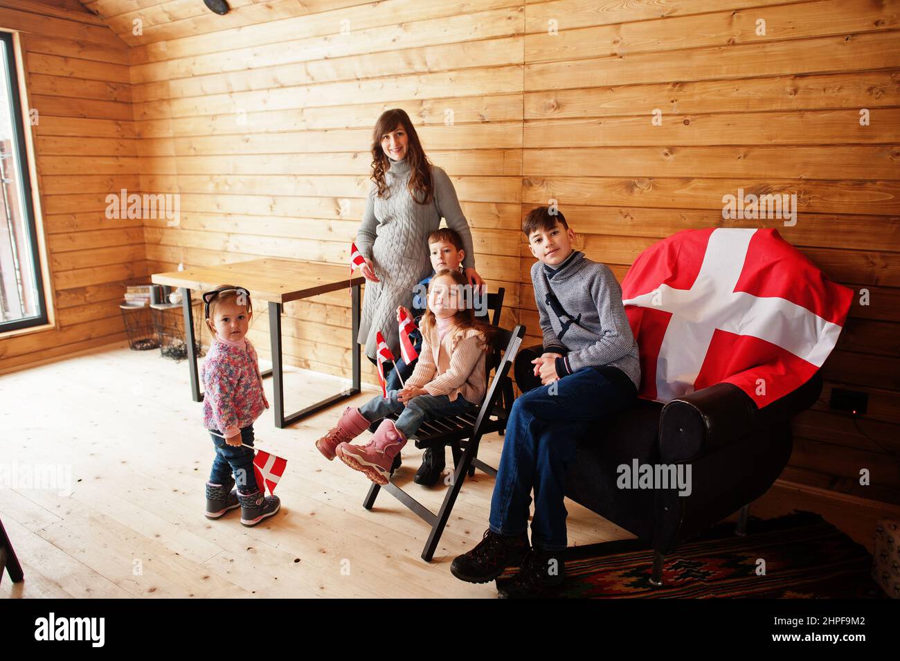 Family with Denmark flags inside wooden house. Travel to Scandinavian ...