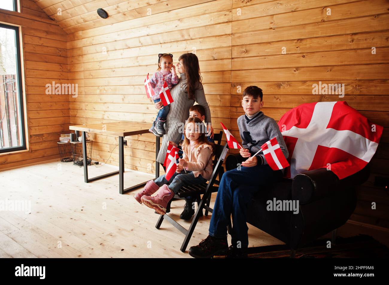 Family with Denmark flags inside wooden house. Travel to Scandinavian ...