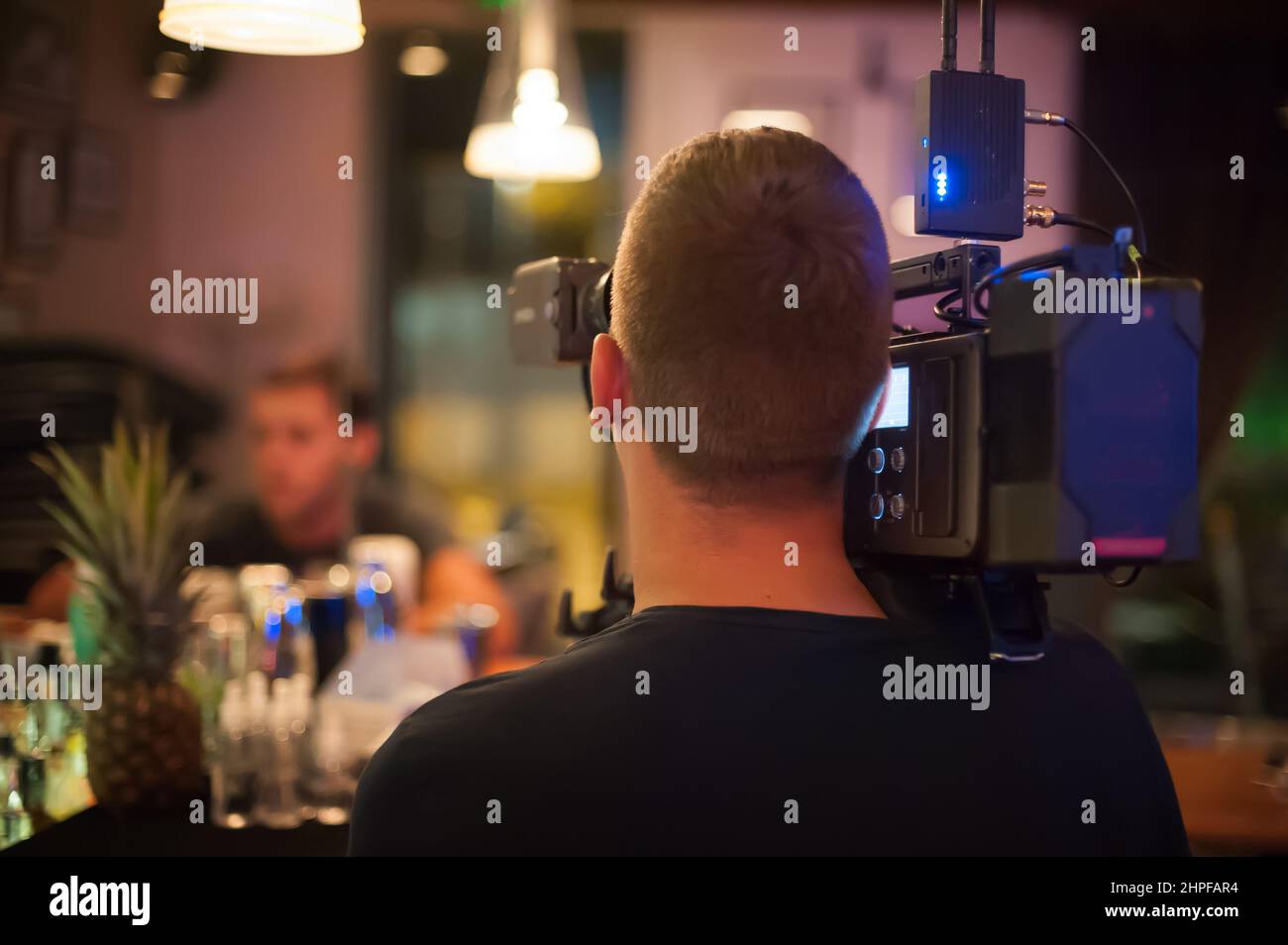 Behind the scenes. Cameraman shooting the film scene with his camera on ...