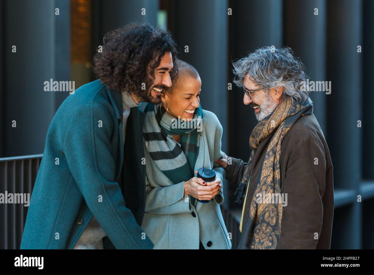Business people having fun and laughing while talking outdoors on the ...