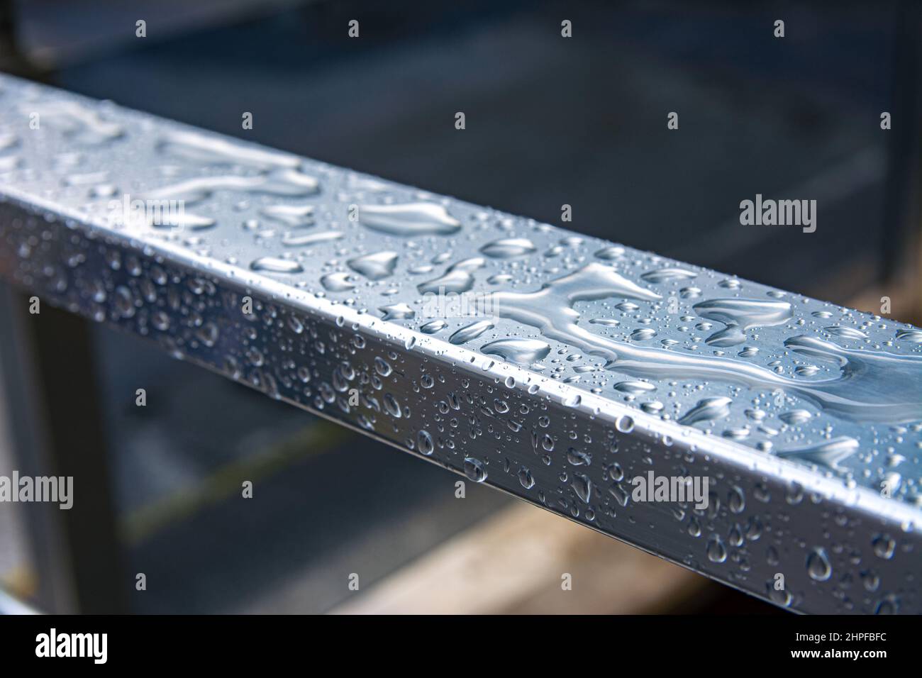 Raindrops on a metal surface. Dew drops on a steel railing close-up ...