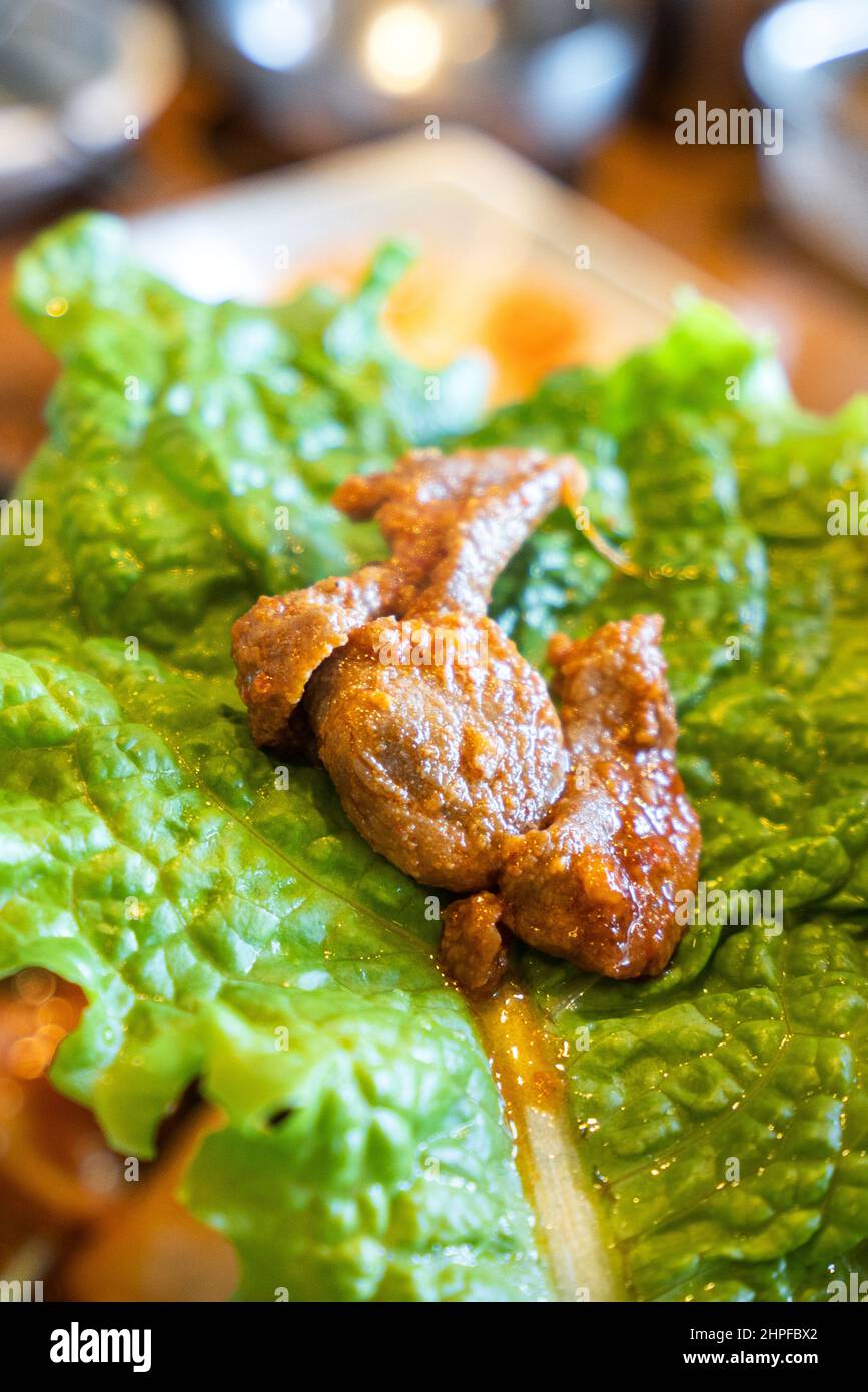 Close up of ssam Korean BBQ, pan-fried black pork with lettuce meal in ...