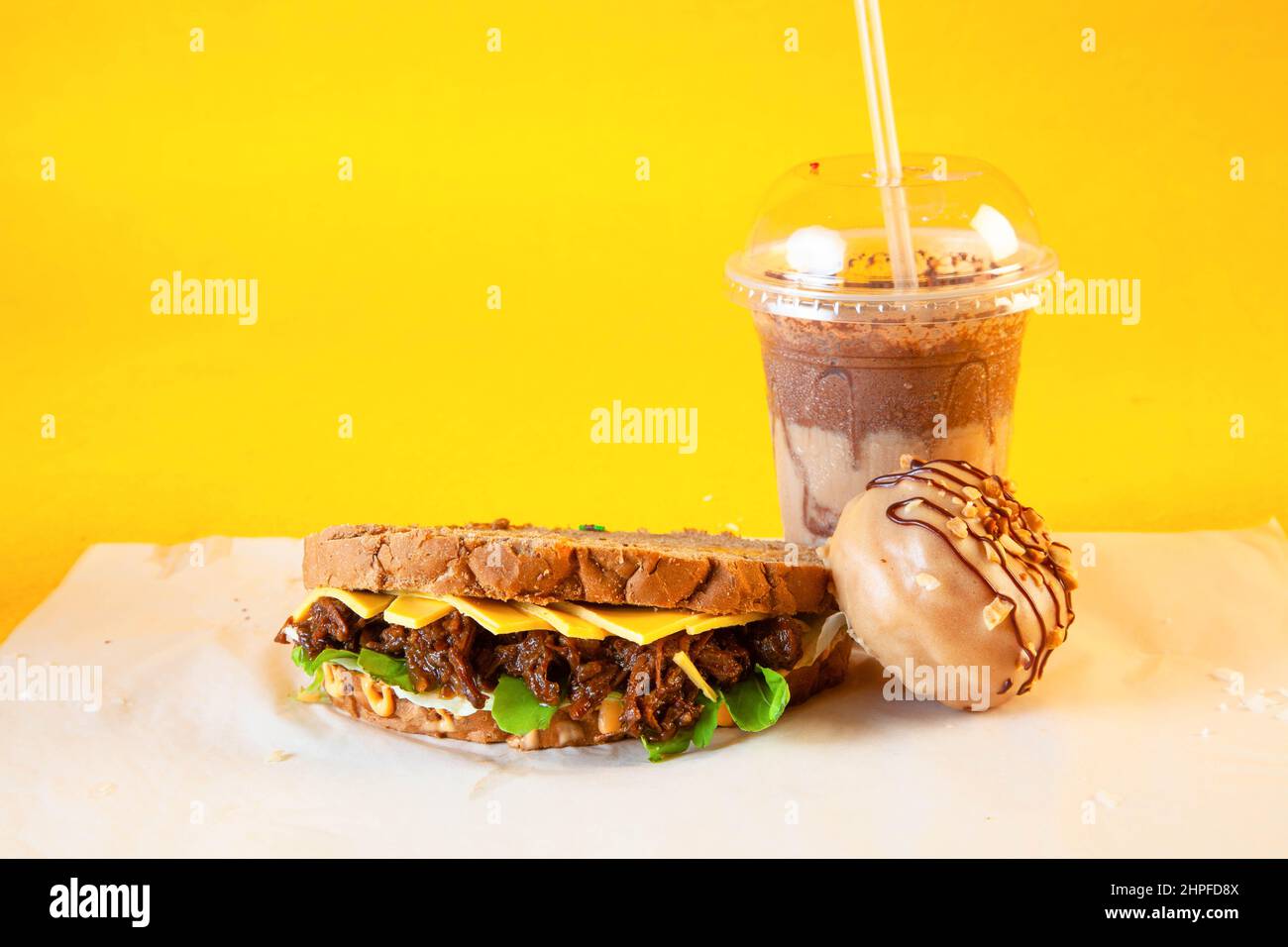 Rye bread pulled beef sandwich with donut and iced coffee drink Stock ...