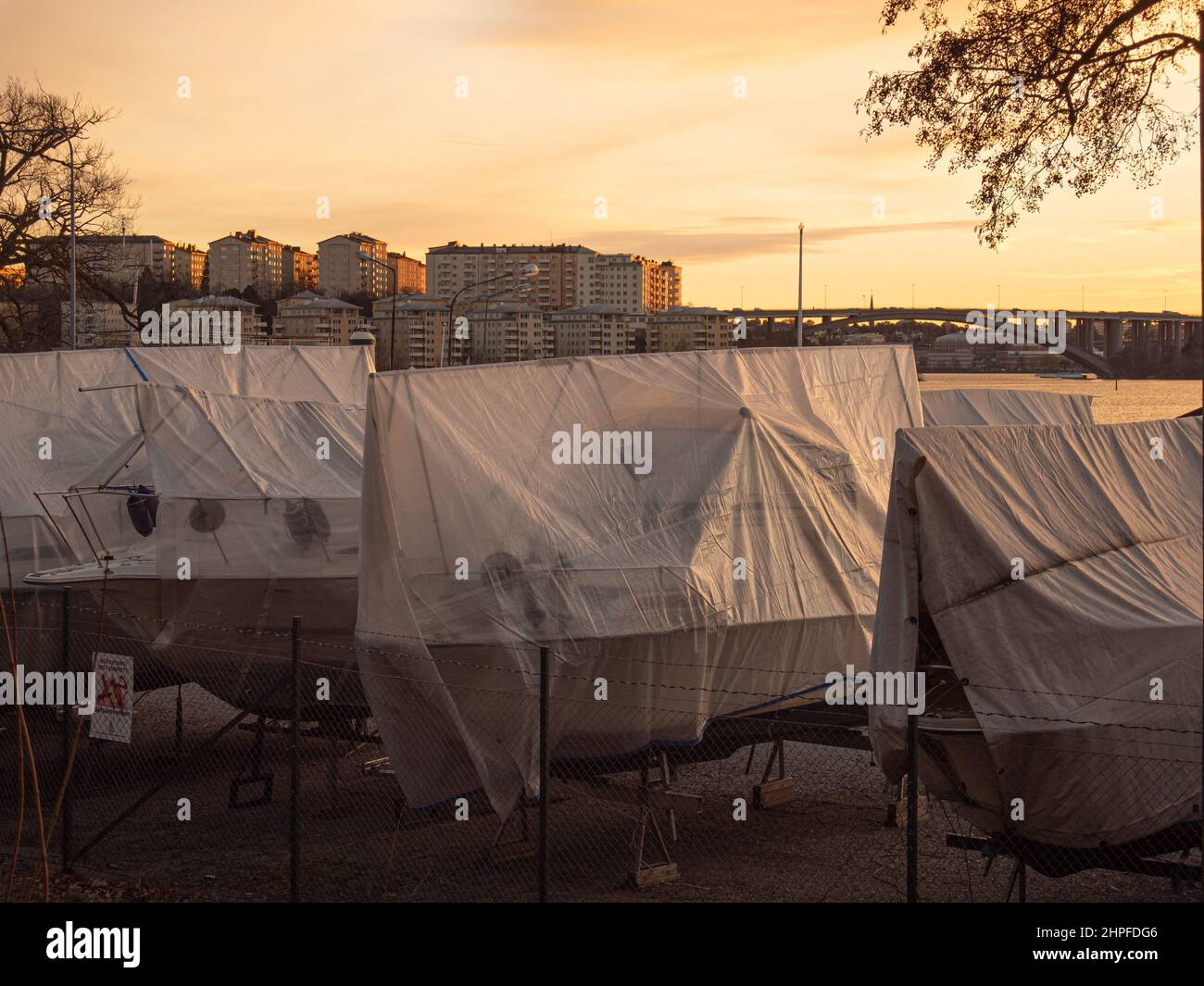 Boats on land covered with tarp Stock Photo - Alamy