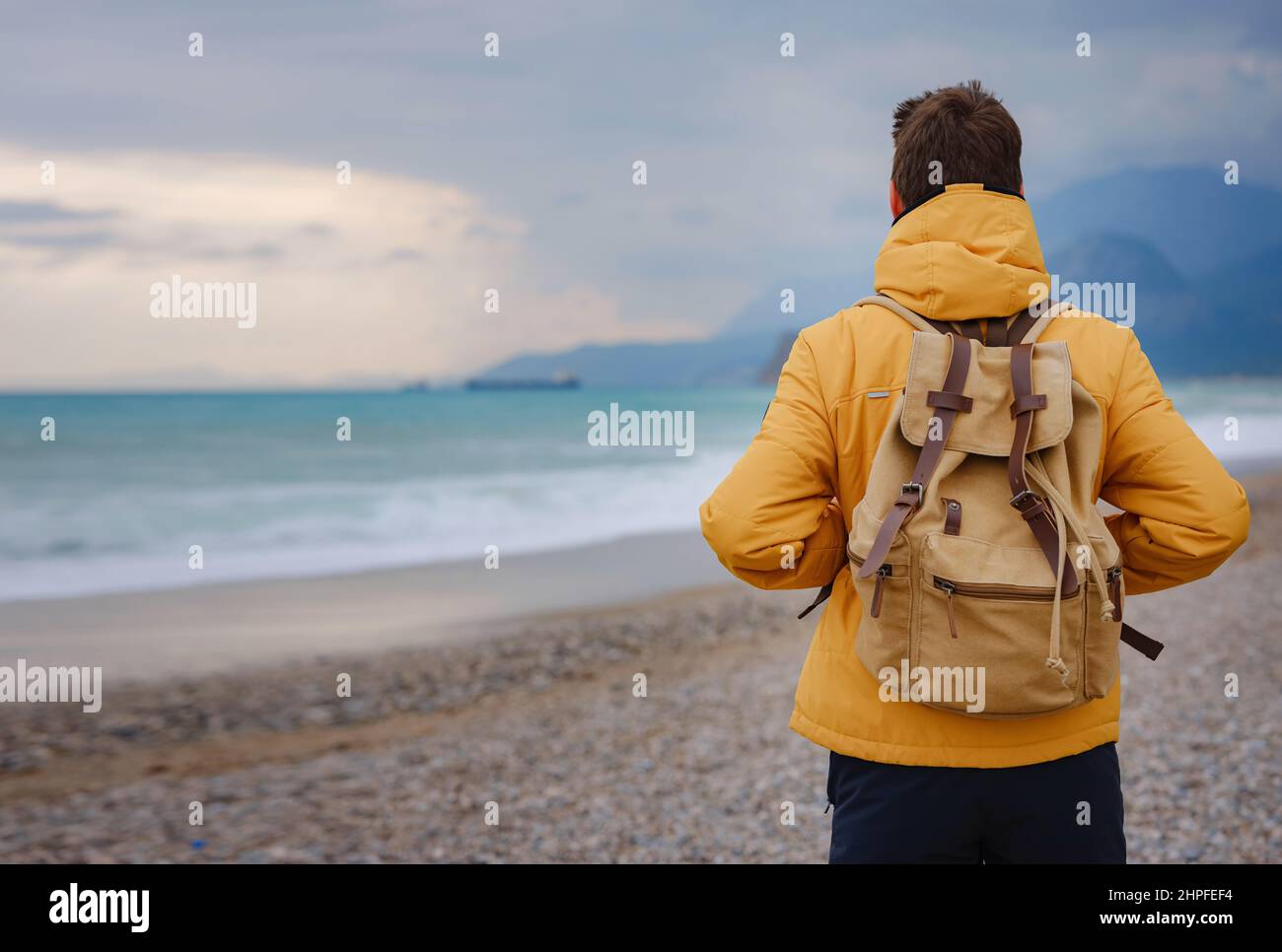 Handsome man in yellow jacket walking beach in antalya, turkey. Good ...
