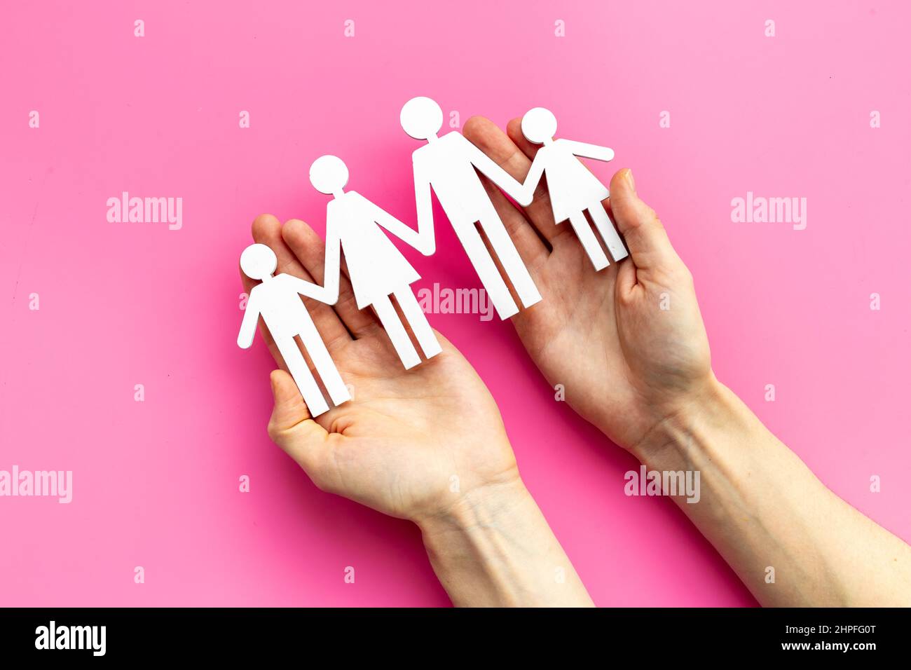 Care of family concept. Wooden figures in hand Stock Photo - Alamy