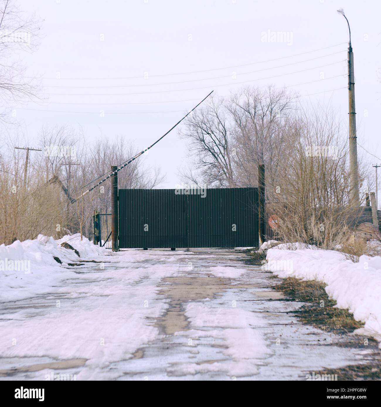 Iron gates and a barrier on an old abandoned road. Restricted area ...