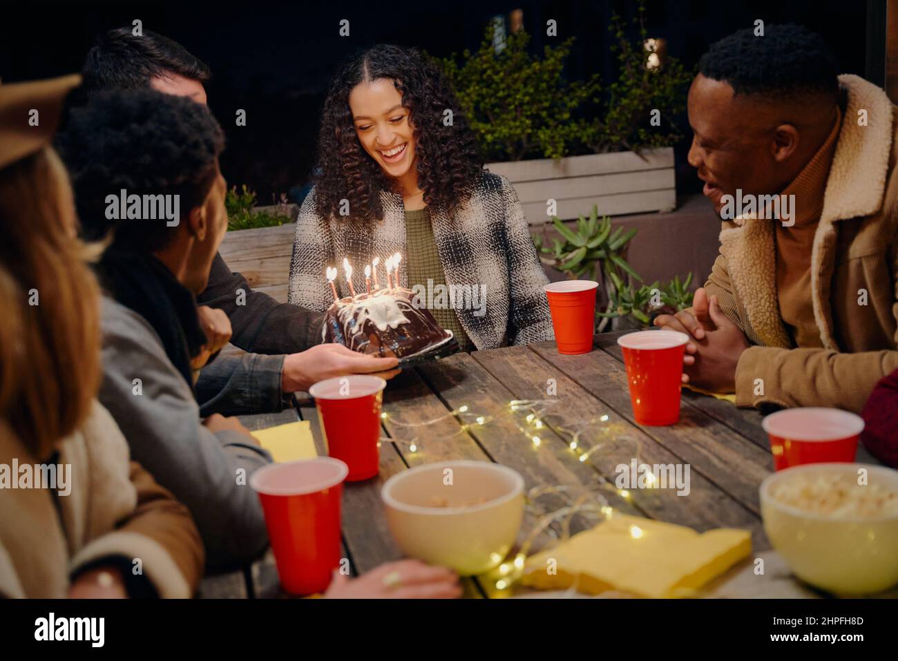 Birthday girl smiling as group of diverse young adults celebrate her ...