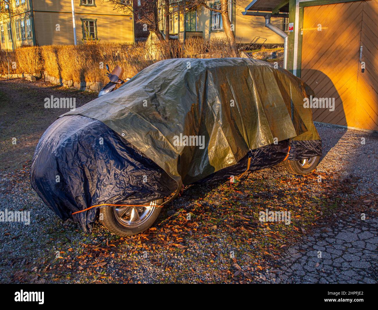 Tarp covered car in front of house Stock Photo - Alamy