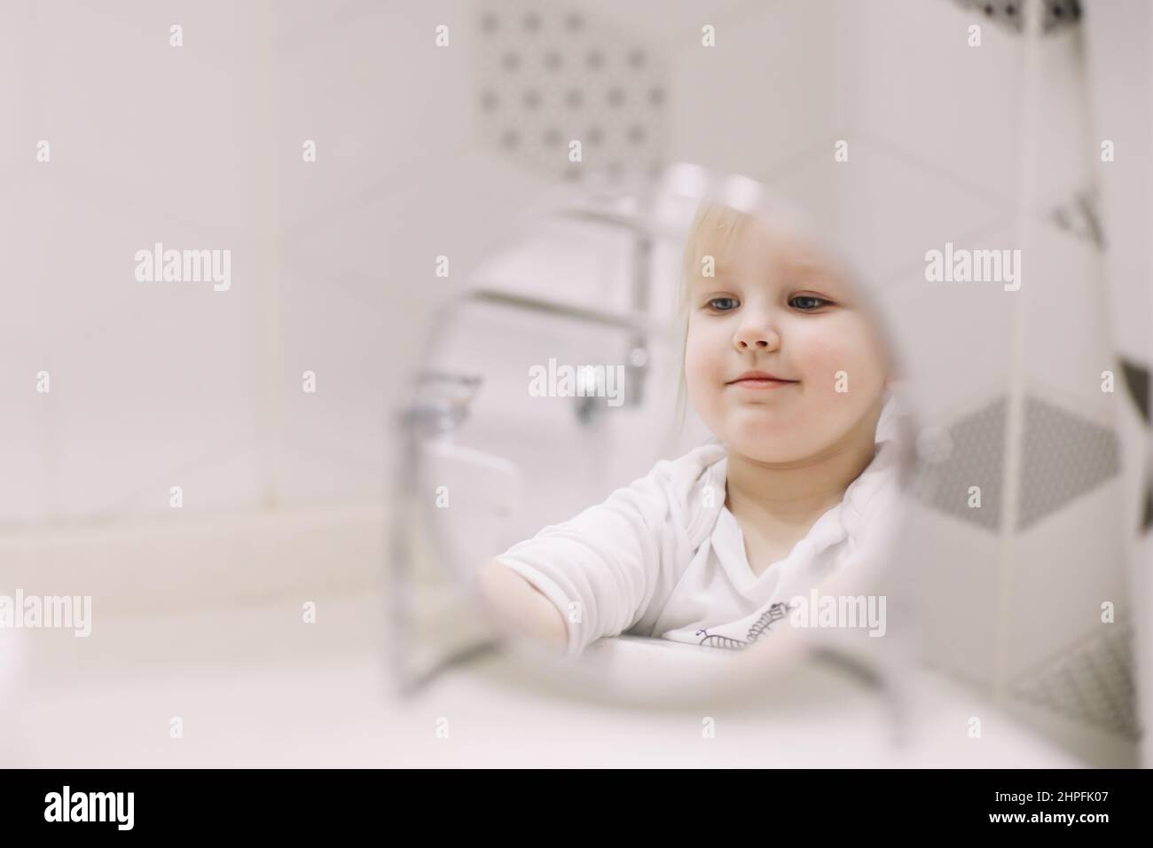 little funny girl brushing teeth and washing hands in the bathroom ...