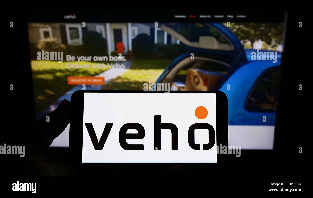 Person holding mobile phone with logo of American delivery company Veho ...