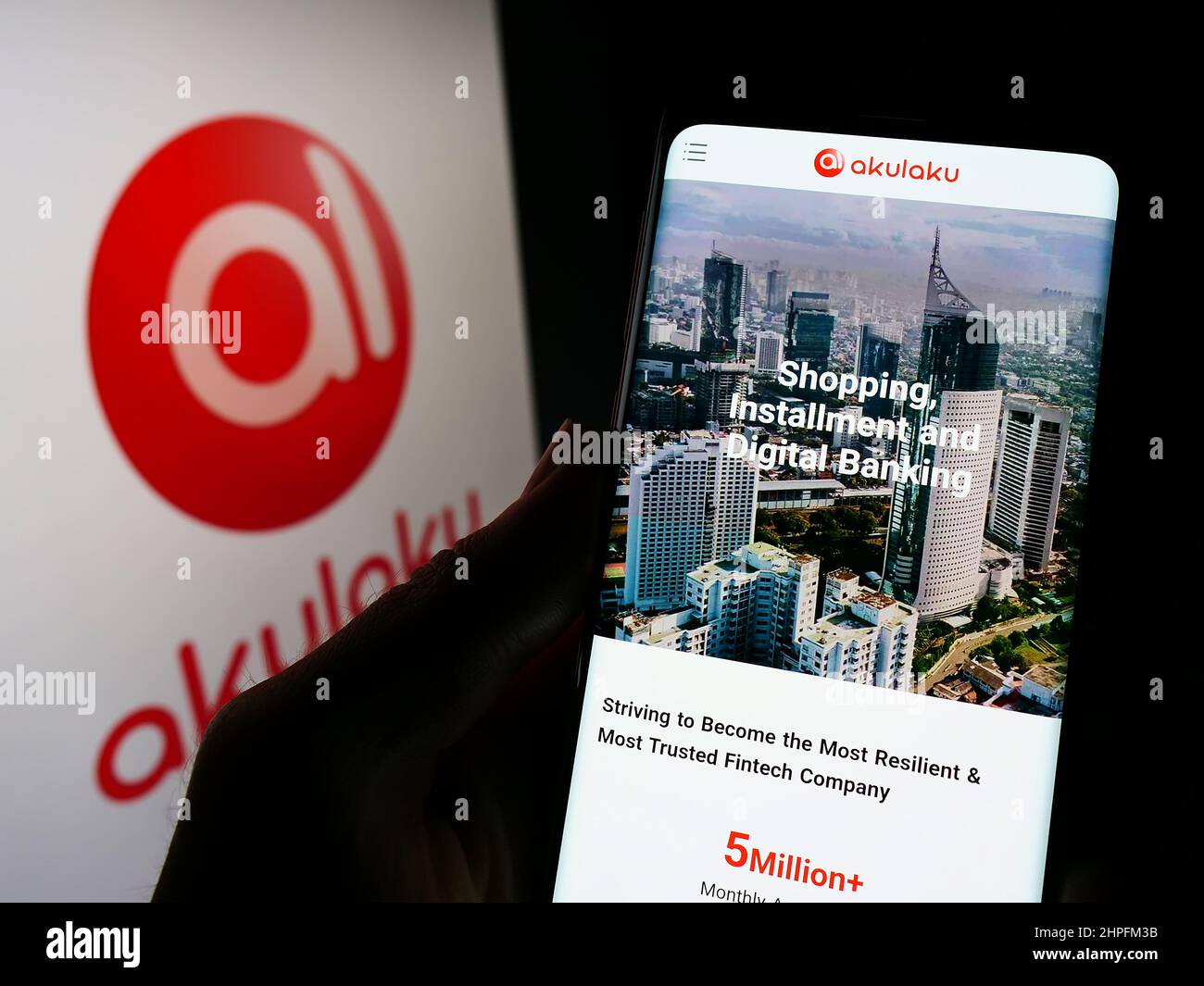 Person holding smartphone with webpage of Asian financial company ...