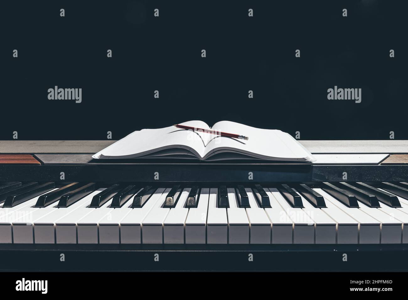 Open notepad on piano keys in the dark, copy space Stock Photo - Alamy