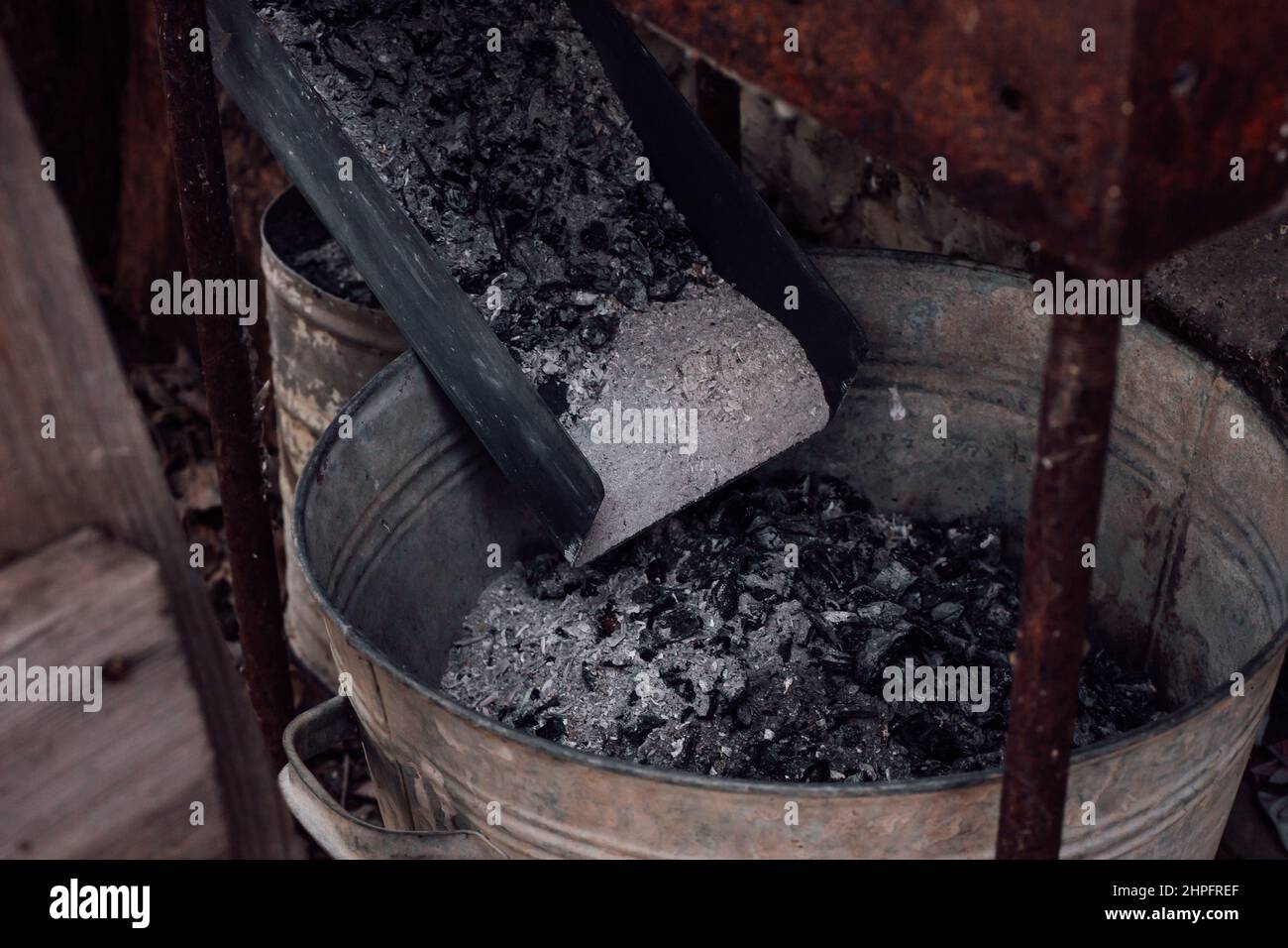 Closeup of ashes from wood put in iron bucket under old brazier used ...