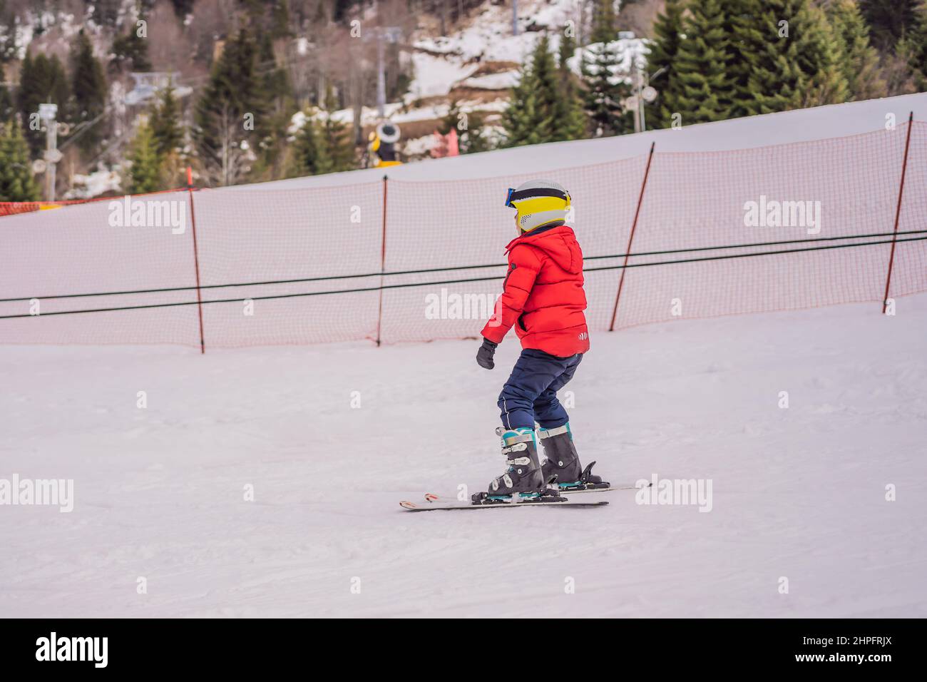 Child skiing in mountains. Active toddler kid with safety helmet ...
