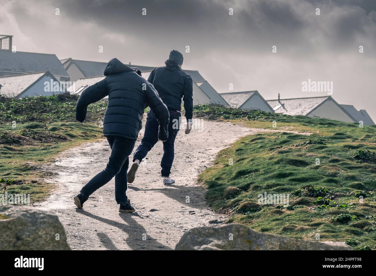 People struggling to walk along a coast path in storm force wind ...