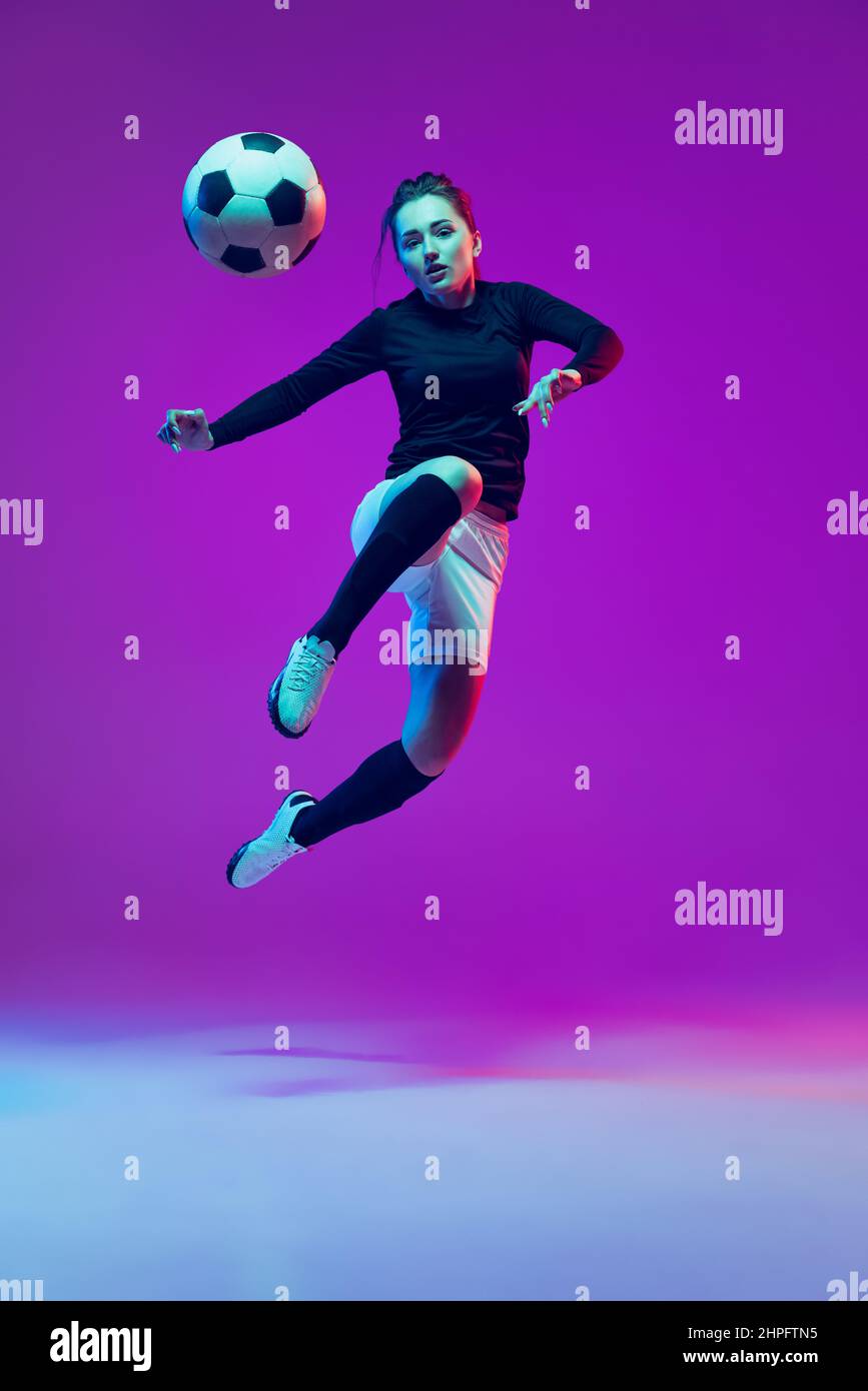 One sportive girl, female soccer player kick in jump football ball ...