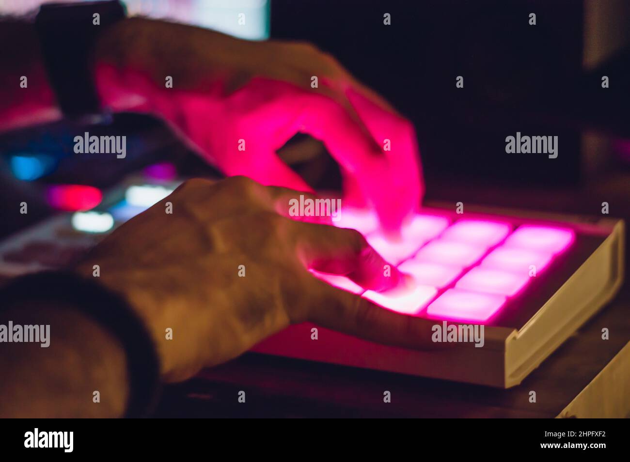 blurred image of male hands using midi controller, making urban and ...
