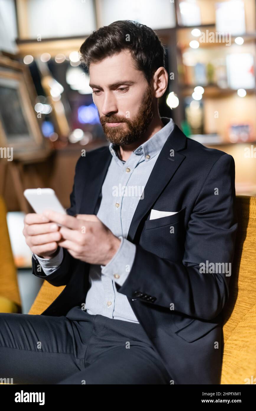 bearded man in suit using cellphone in hotel lobby Stock Photo - Alamy