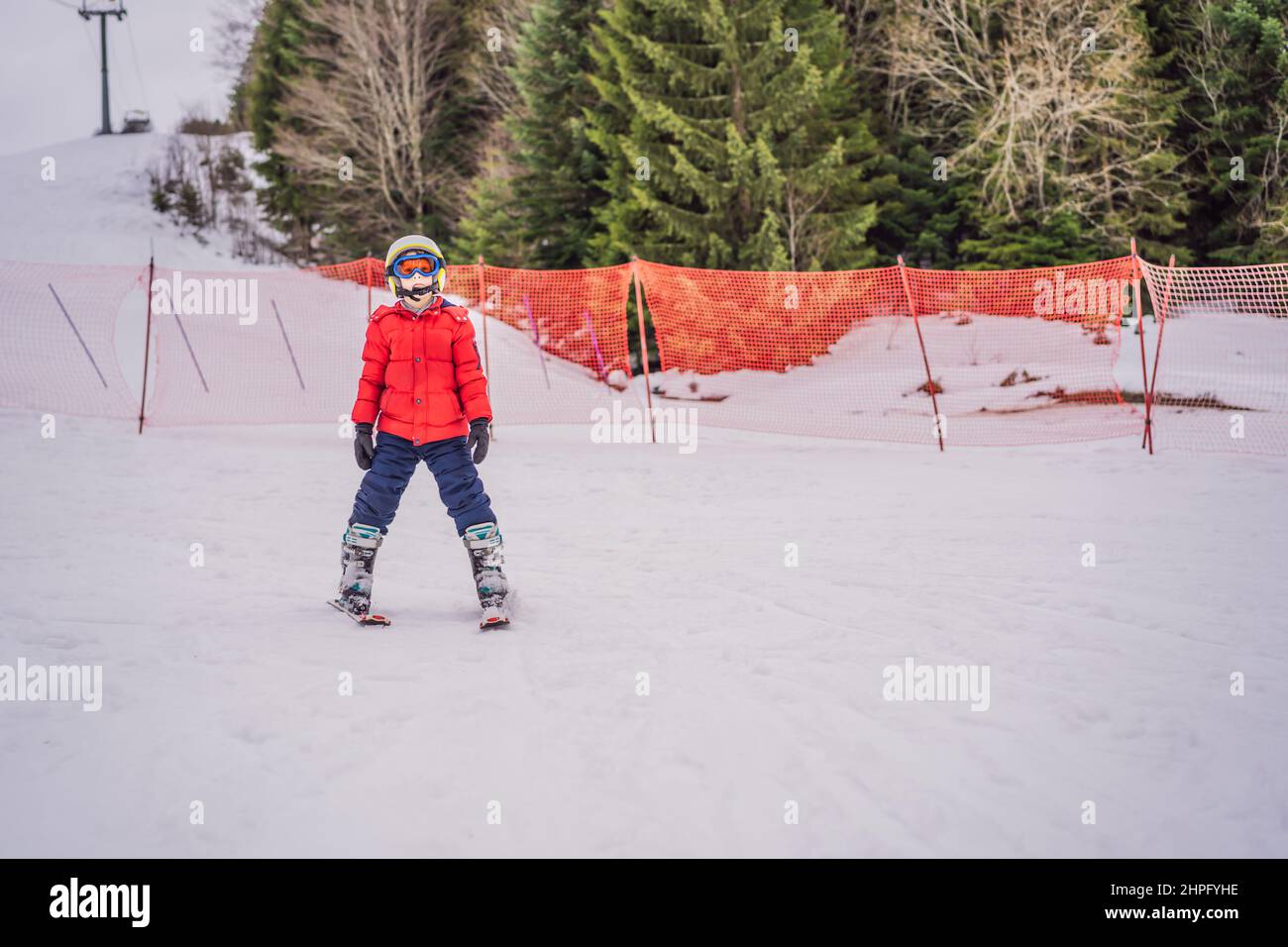 Child skiing in mountains. Active toddler kid with safety helmet ...
