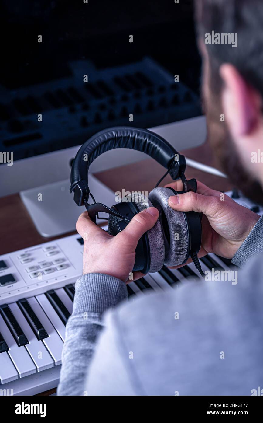 Male musician creates music using computer and keyboard, musician ...