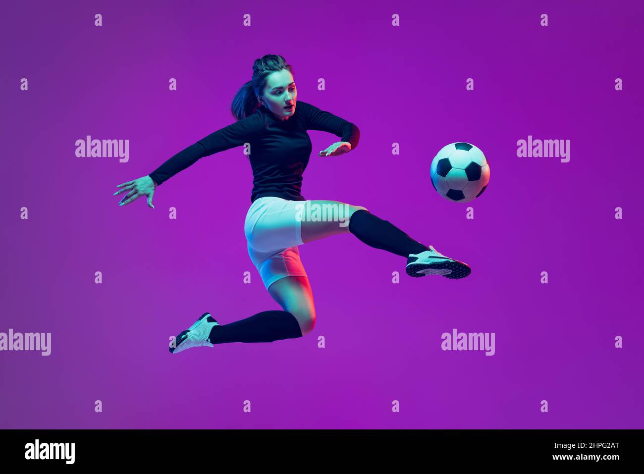 One sportive girl, female soccer player kick in jump football ball ...
