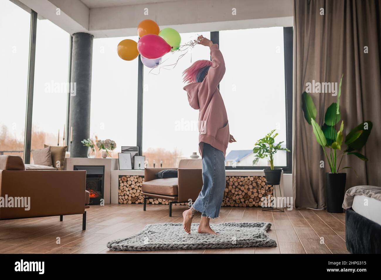 A happy girl dancing wiht a bunch of colorful balloons Stock Photo - Alamy