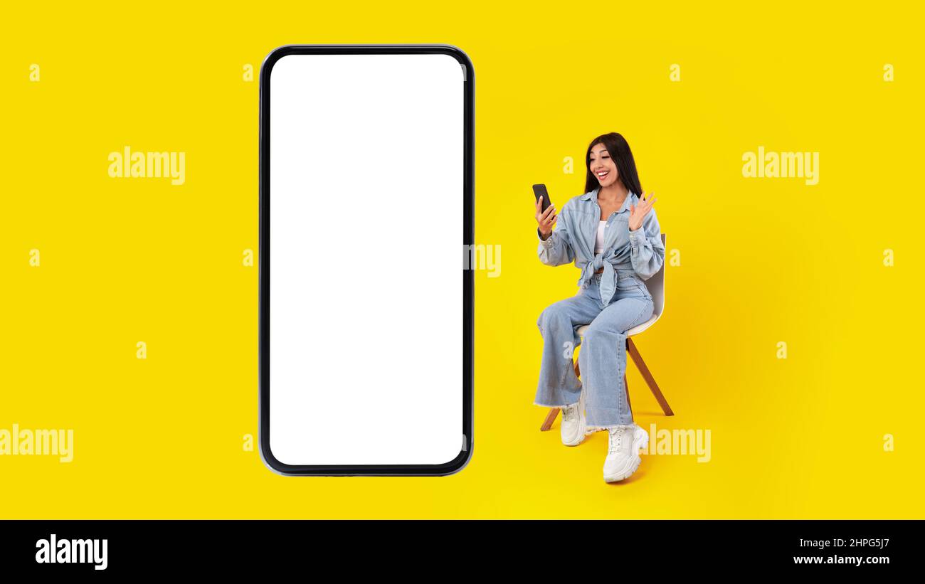 Cheerful young woman making video call using cell, talking waving hand ...