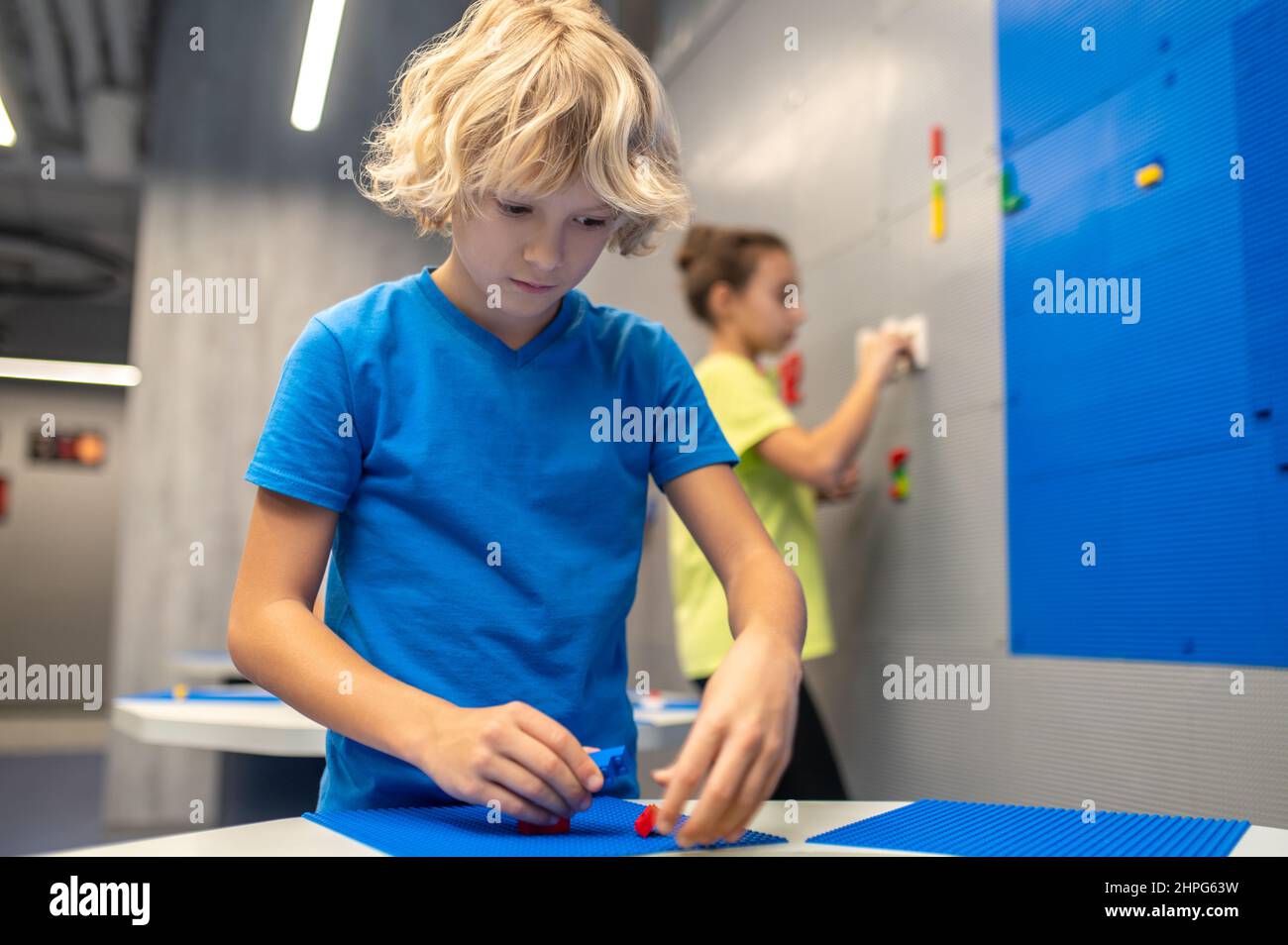 Boy looking carefully attaching lego pieces Stock Photo - Alamy