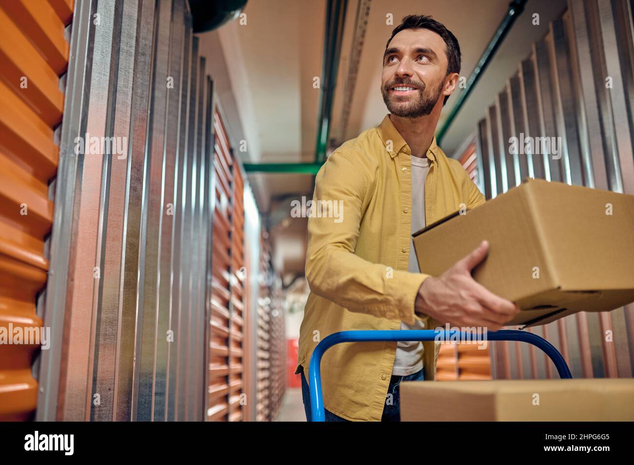 Joyful worker unloading items in the warehouse Stock Photo - Alamy