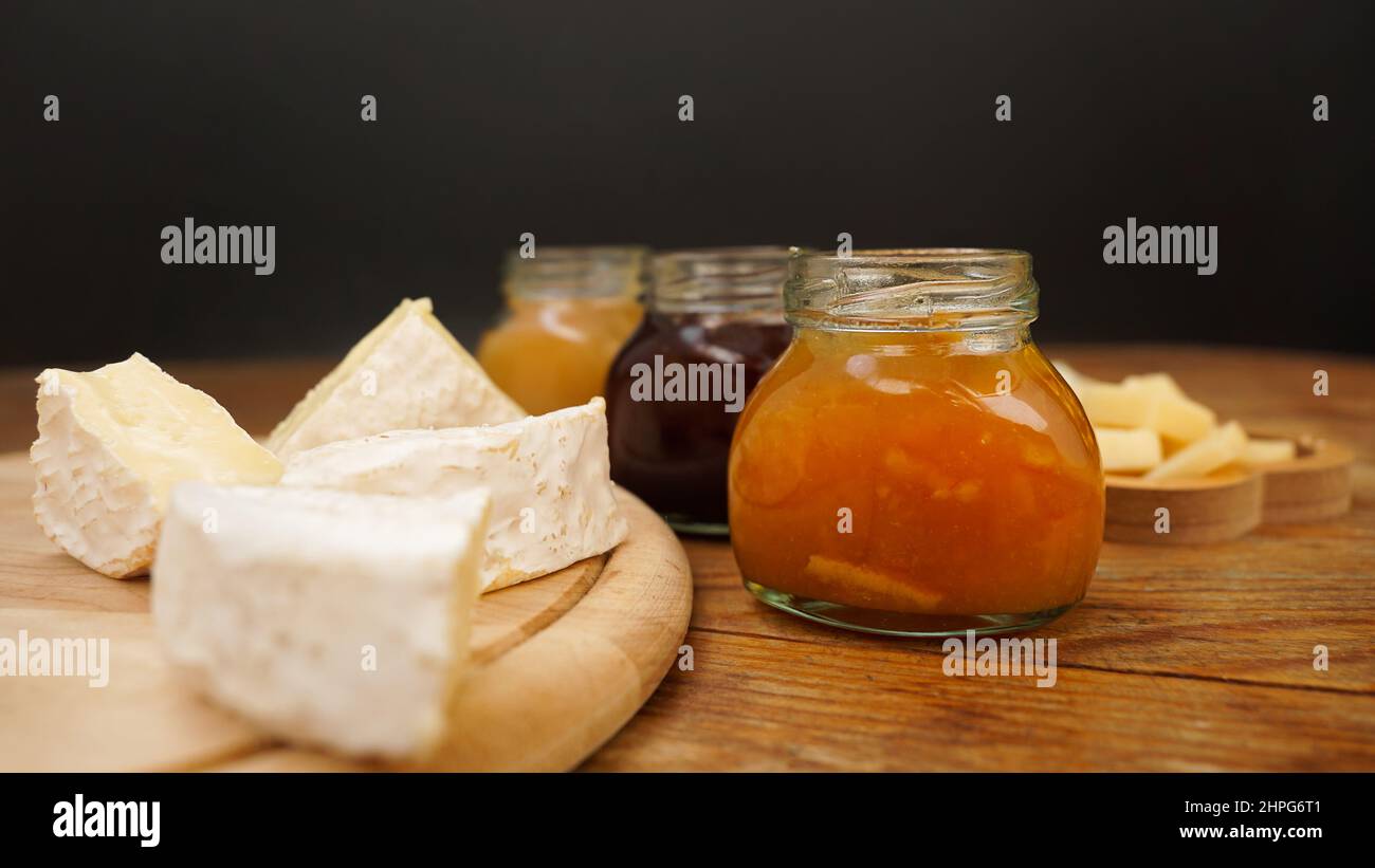 Jars of homemade jams and honey in glass jars and a variety of cheeses ...