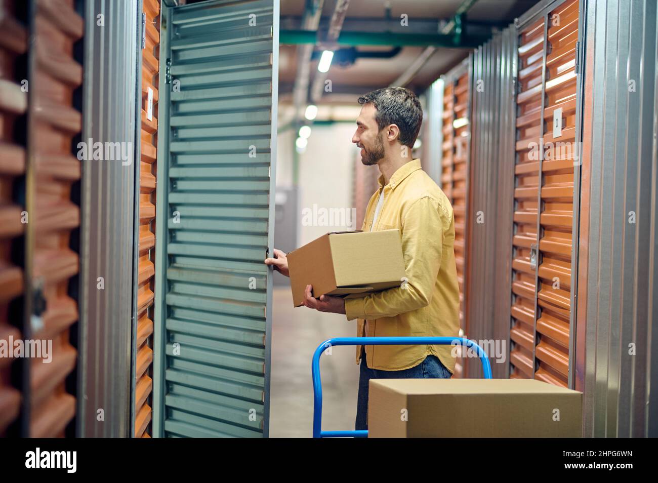 Contented loader unloading items in the warehouse Stock Photo - Alamy