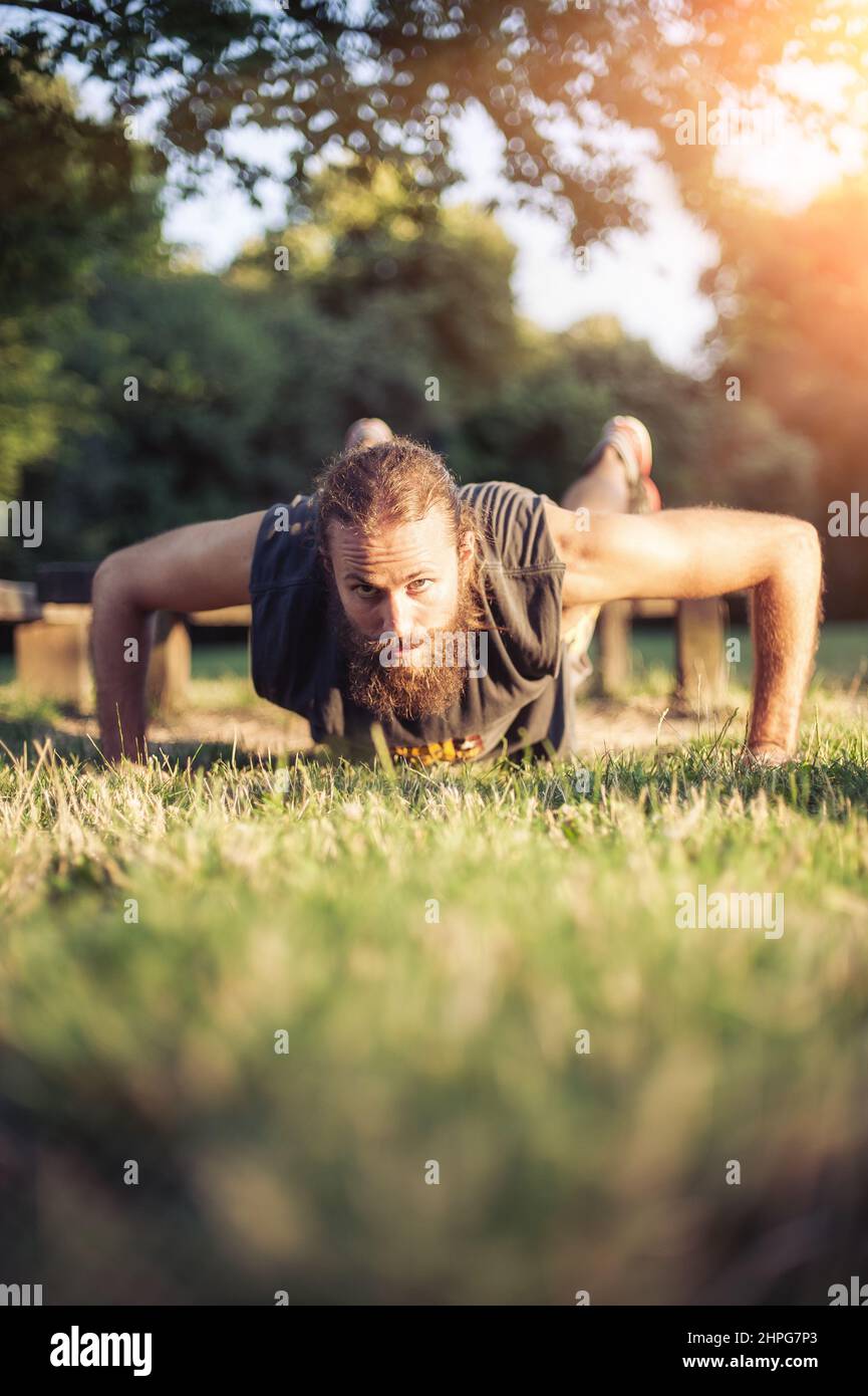 Training outdoors. Handsome sport man doing pushups in the park on the sunny day Stock Photo - Alamy