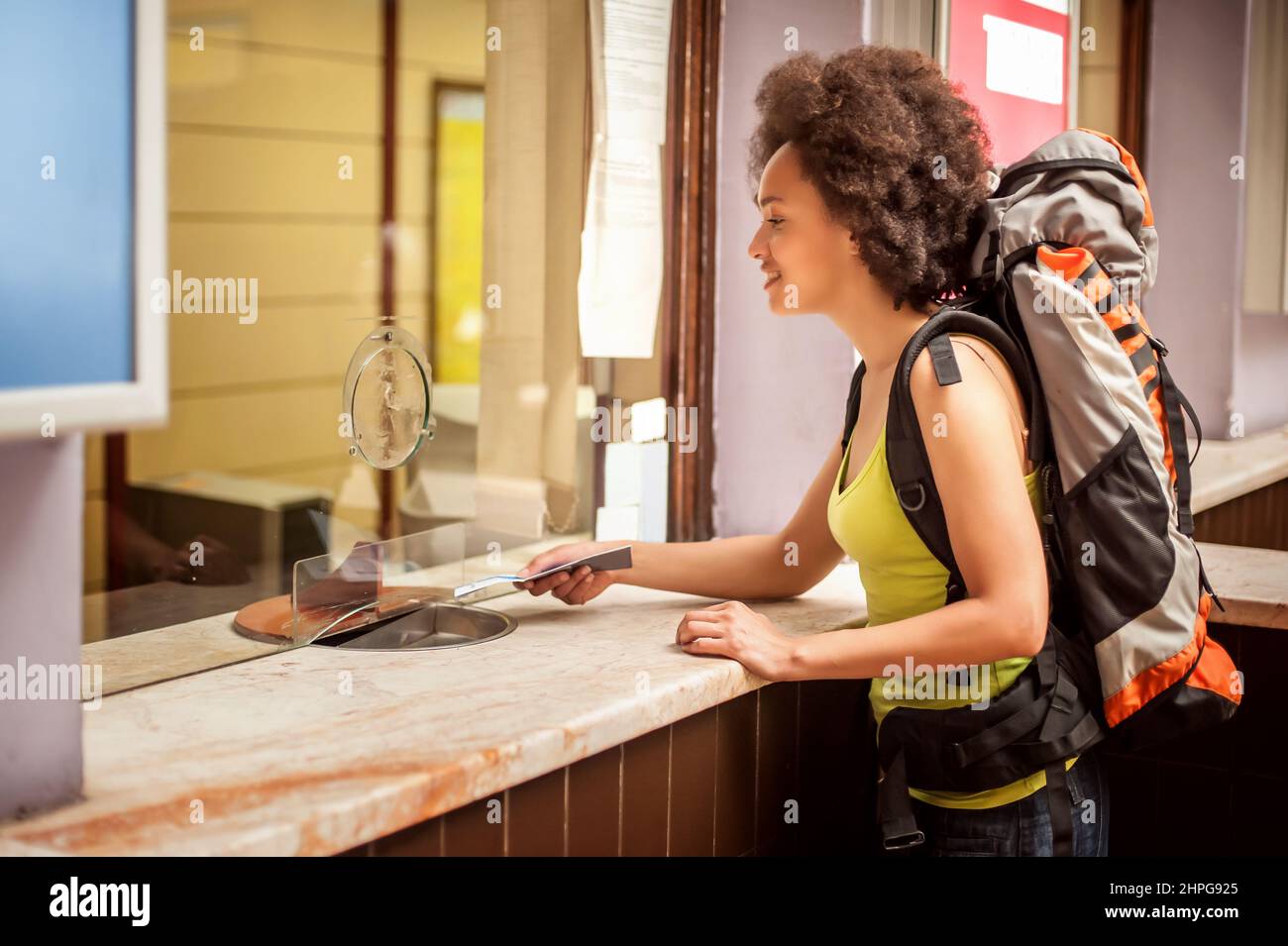 Beautiful female tourist buys a ticket for her journey at terminal ...