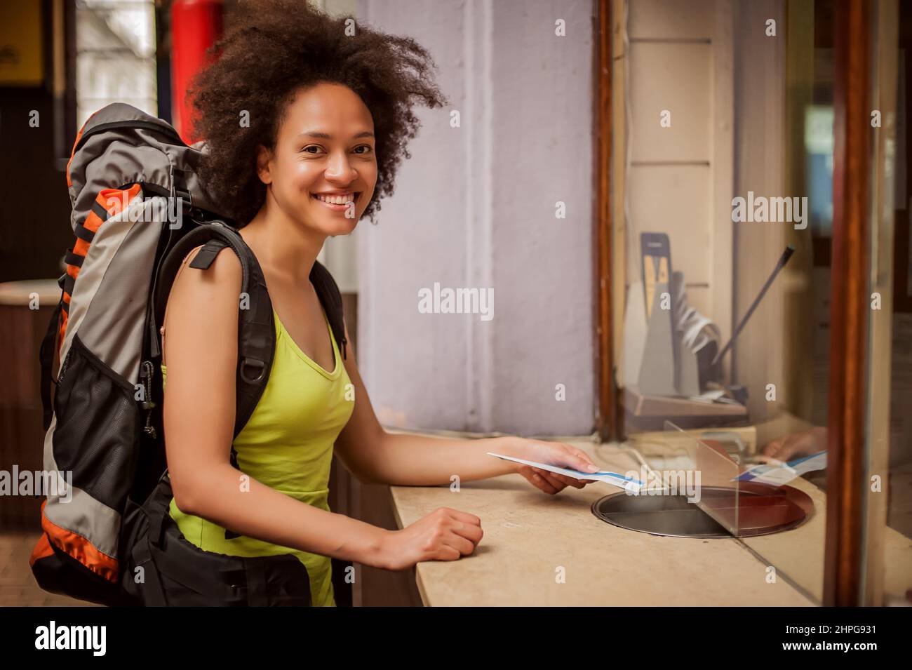 Beautiful female backpacker tourist buys a ticket for her journey at ...