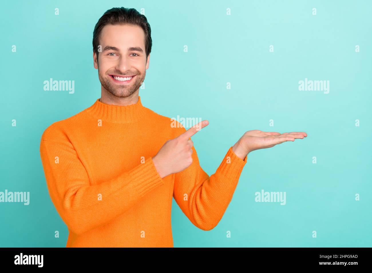 Portrait of positive man finger direct hand palm hold empty space ...