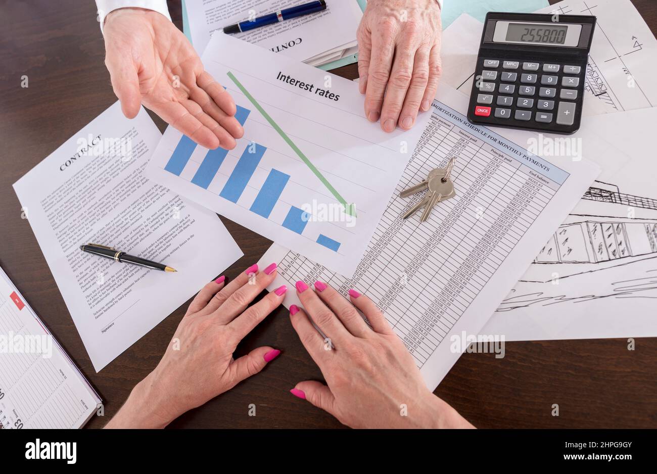 Estate agent showing the decrease of interest rates to his client ...