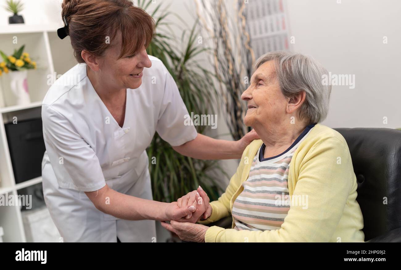 Nurse supporting elderly woman hi-res stock photography and images - Alamy