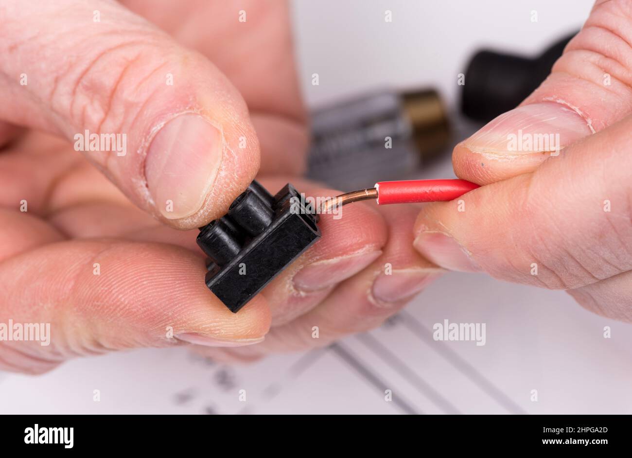 Hand putting a wire in a connector Stock Photo - Alamy