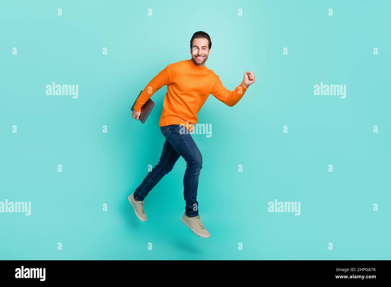 Full body portrait of excited crazy cheerful guy hold netbook running ...