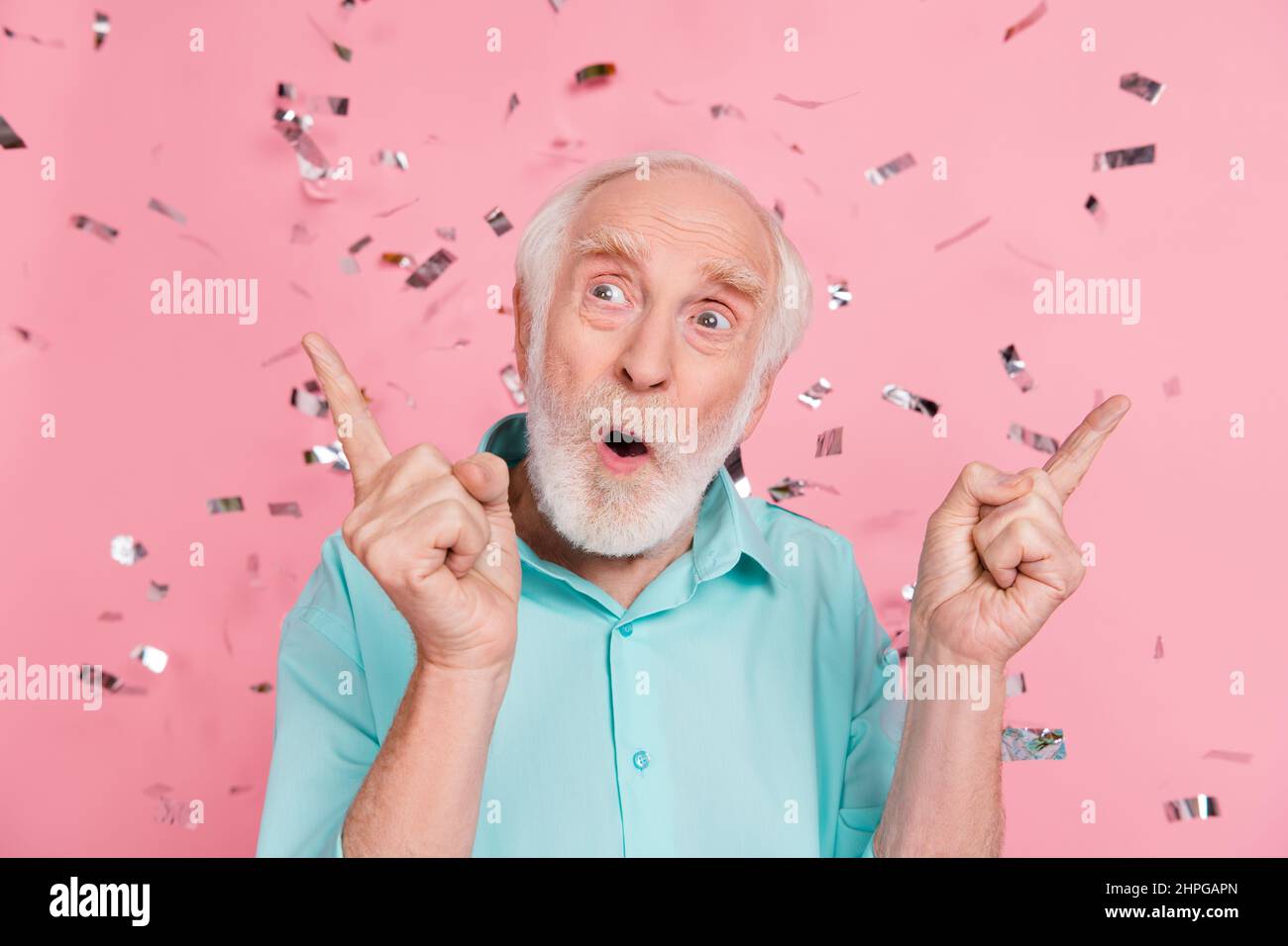 Portrait of middle aged man fall confetti point finger empty space ...