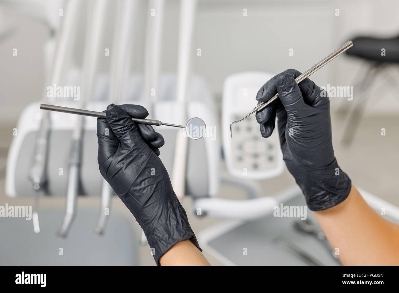 Close-up of female doctor's hands in black gloves holding dental ...