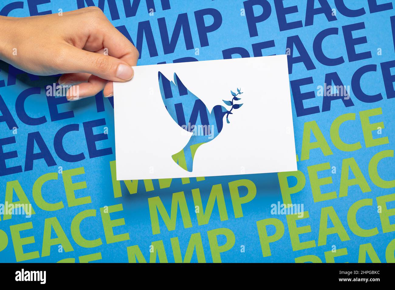 woman holding a cardboard with cut out Dove of peace Symbol and text ...