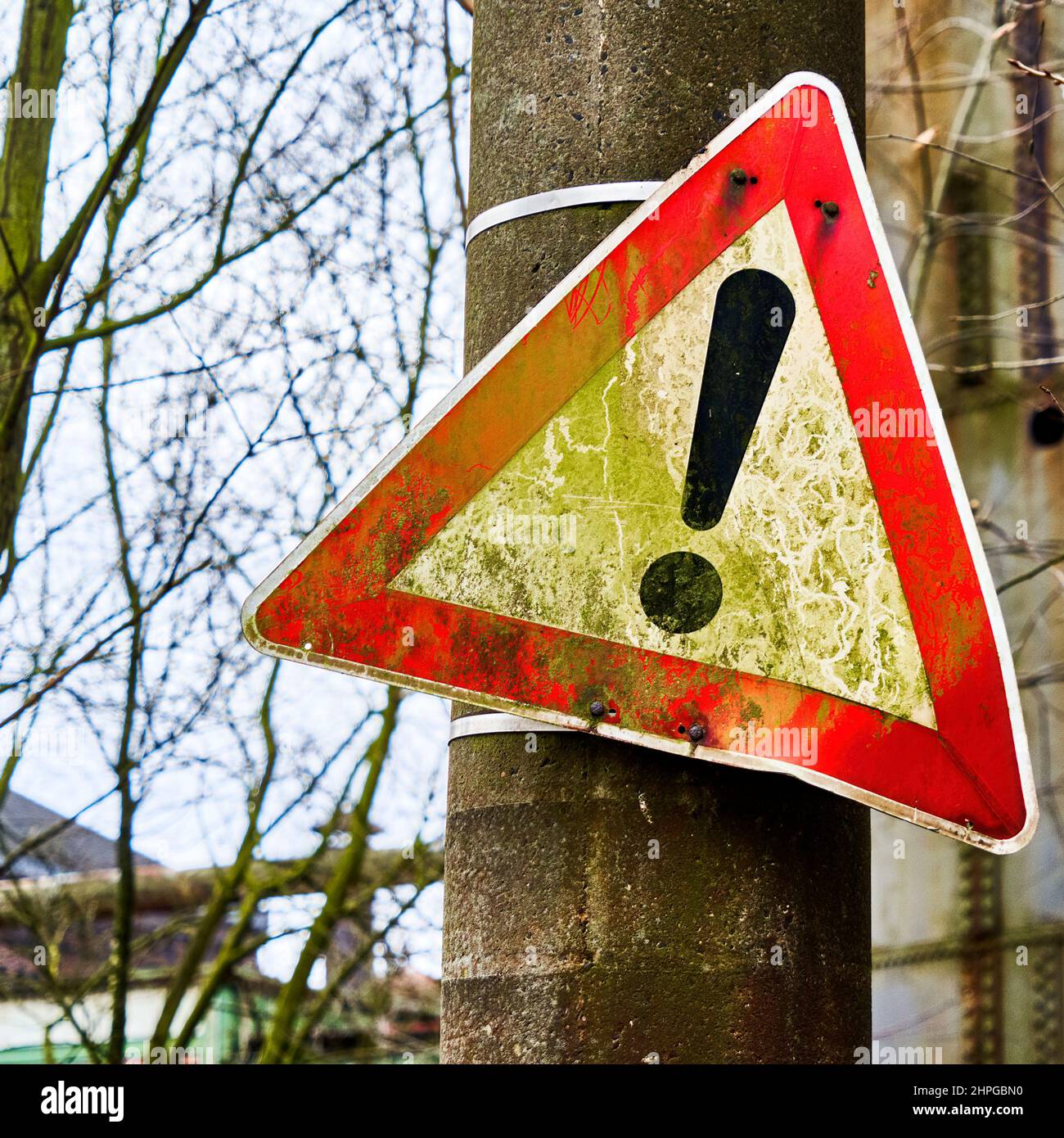 Bent warning sign overgrown with moss, algae and lichen attached ...