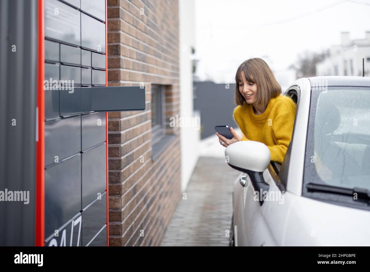 Woman opens post terminal cell using smart phone right out of the car ...