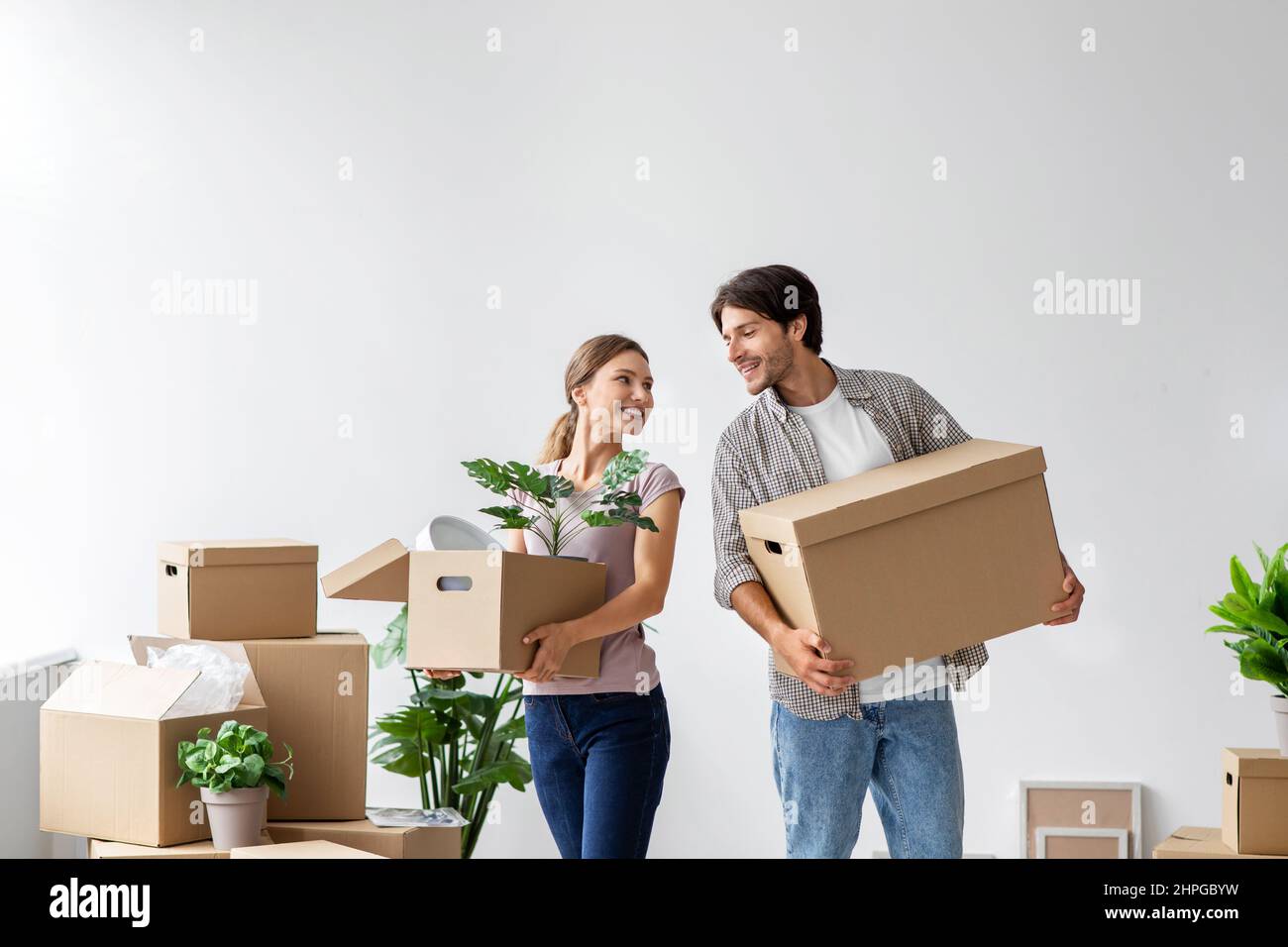 Glad happy young caucasian guy and lady in casual enjoy moving at new ...