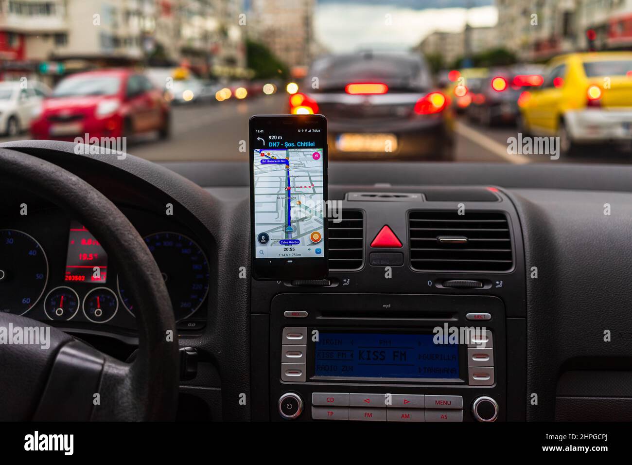 Driving and using waze maps application on smartphone on car dashboard ...