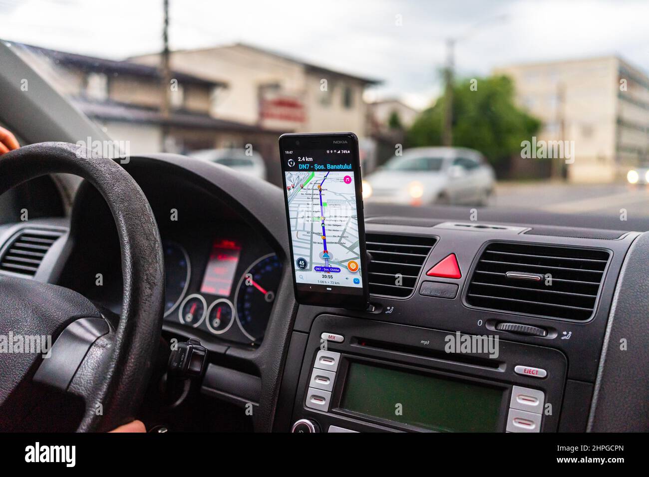 Driving and using waze maps application on smartphone on car dashboard ...